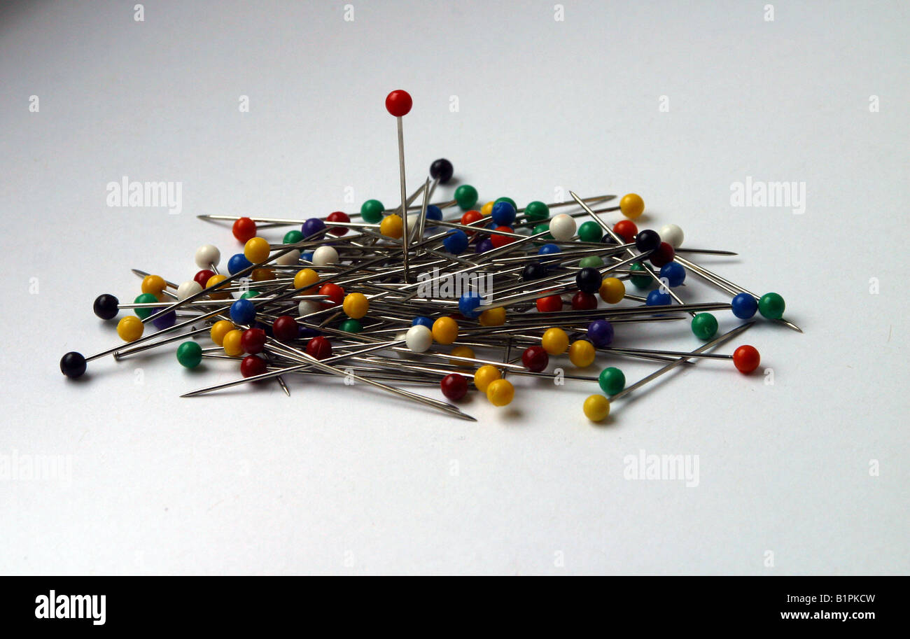 coloured pins in a heap with one red pin standing out from the rest ...