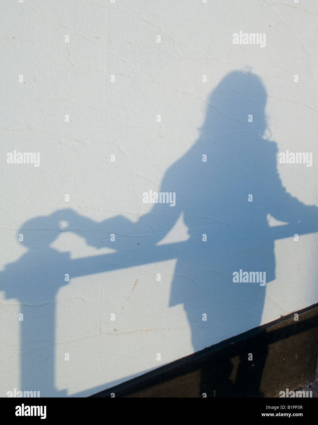 Shadow of a woman leaning on railings Stock Photo - Alamy