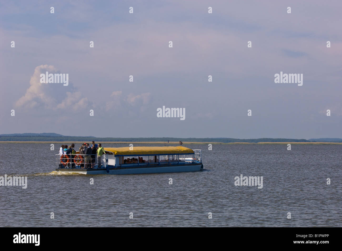 Tourists in leisure boat crossing Lebskie Lake near Leba Slowinski ...