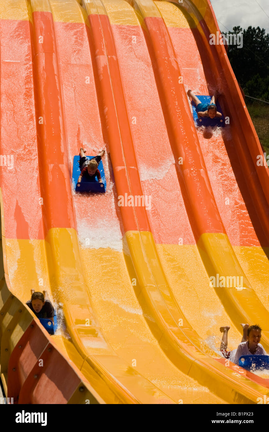 Children sliding down waterslide at waterpark Stock Photo - Alamy
