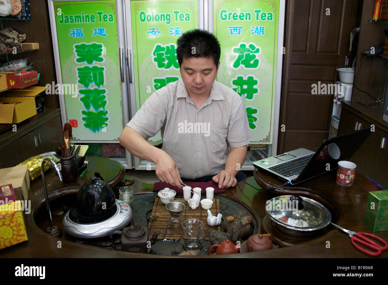 A Chinese tea salesman demonstrating the preparation of Chinese green ...