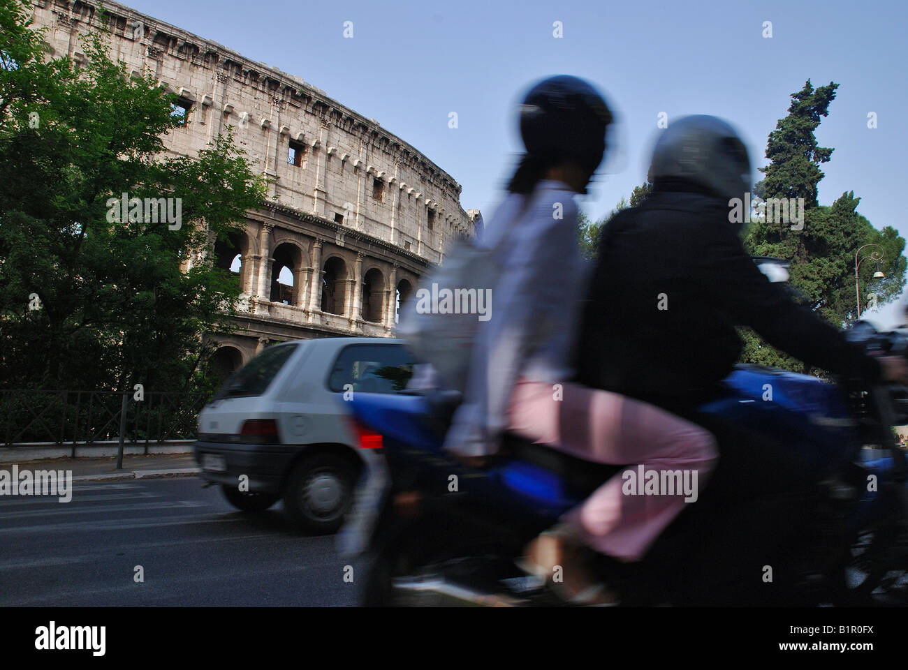 Italian couple scooting with Motorbike by the Coliseum in Rome, Italy ...