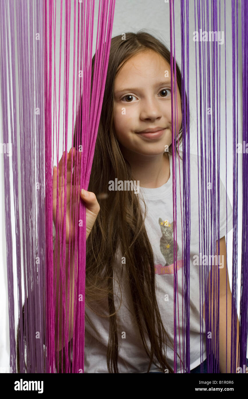 A girl peering through a string curtain Stock Photo - Alamy