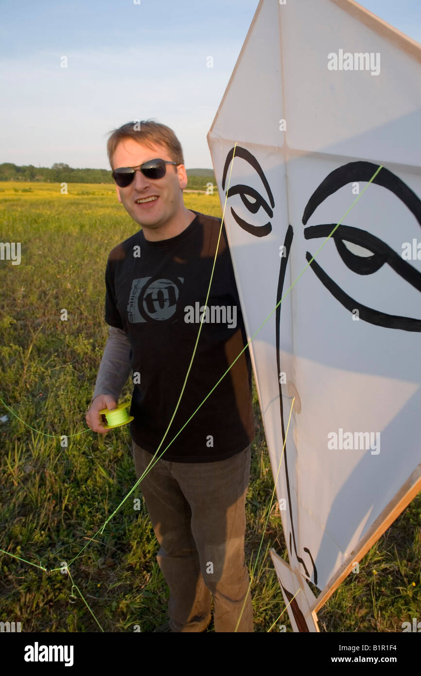 An adult man is playing with his self-made kite in a field Stock Photo ...