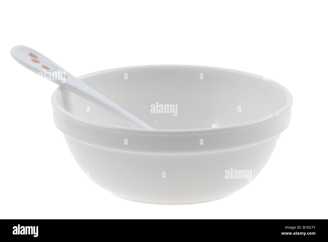 A white dish with a china spoon inside Stock Photo - Alamy