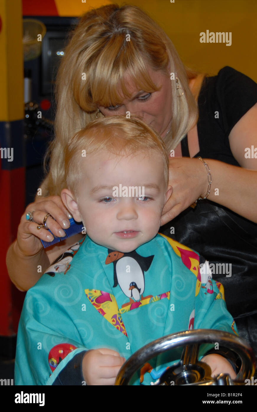 A toddler gets ready for his first hair cut at a children's salon Stock ...