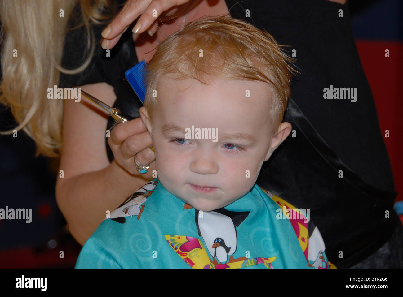 A toddler gets ready for his first hair cut at a children's salon Stock ...