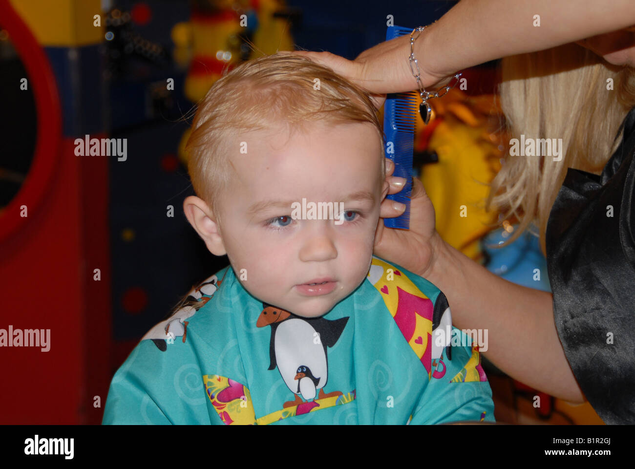 A toddler gets ready for his first hair cut at a children's salon Stock ...