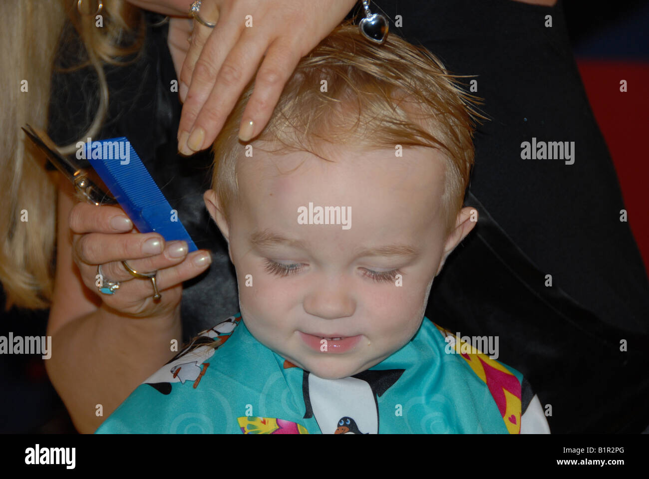 A toddler gets ready for his first hair cut at a children's salon Stock ...