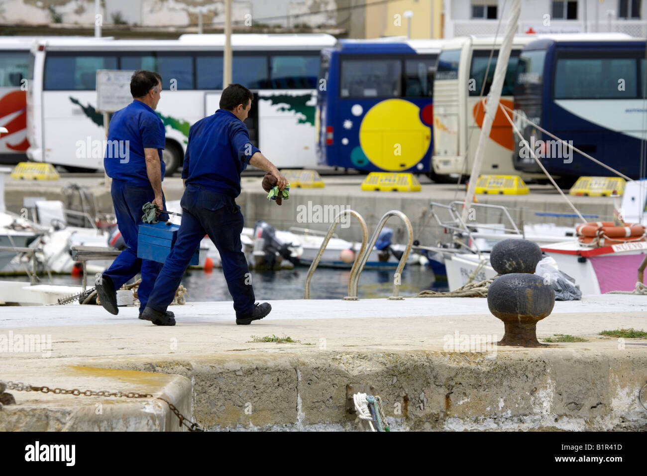 Two men in blue fatigues carrying a toolbox between them, Tarifa ...