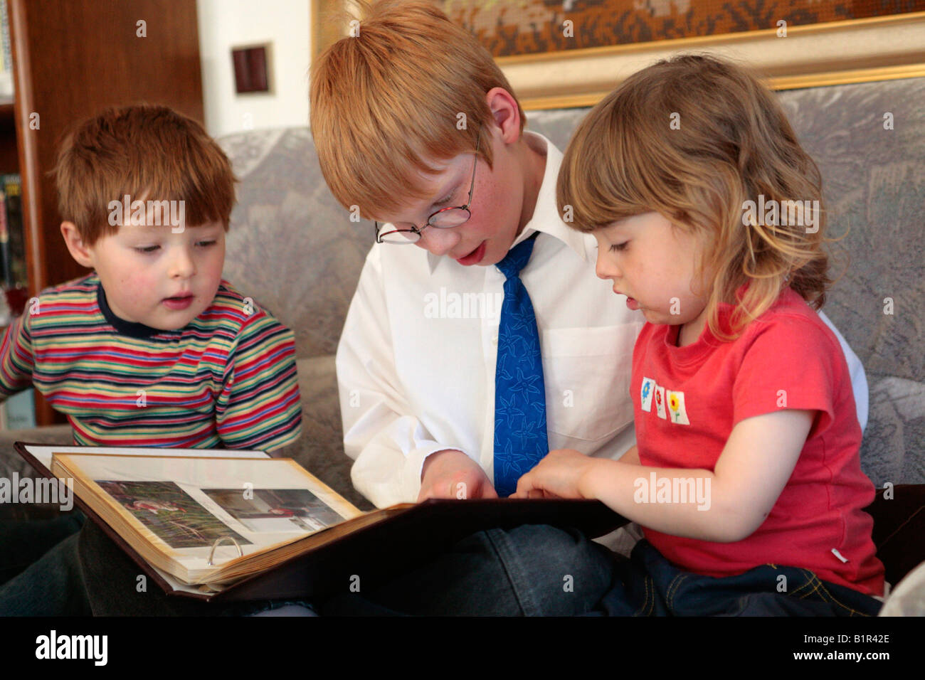 children looking at photo album Stock Photo - Alamy