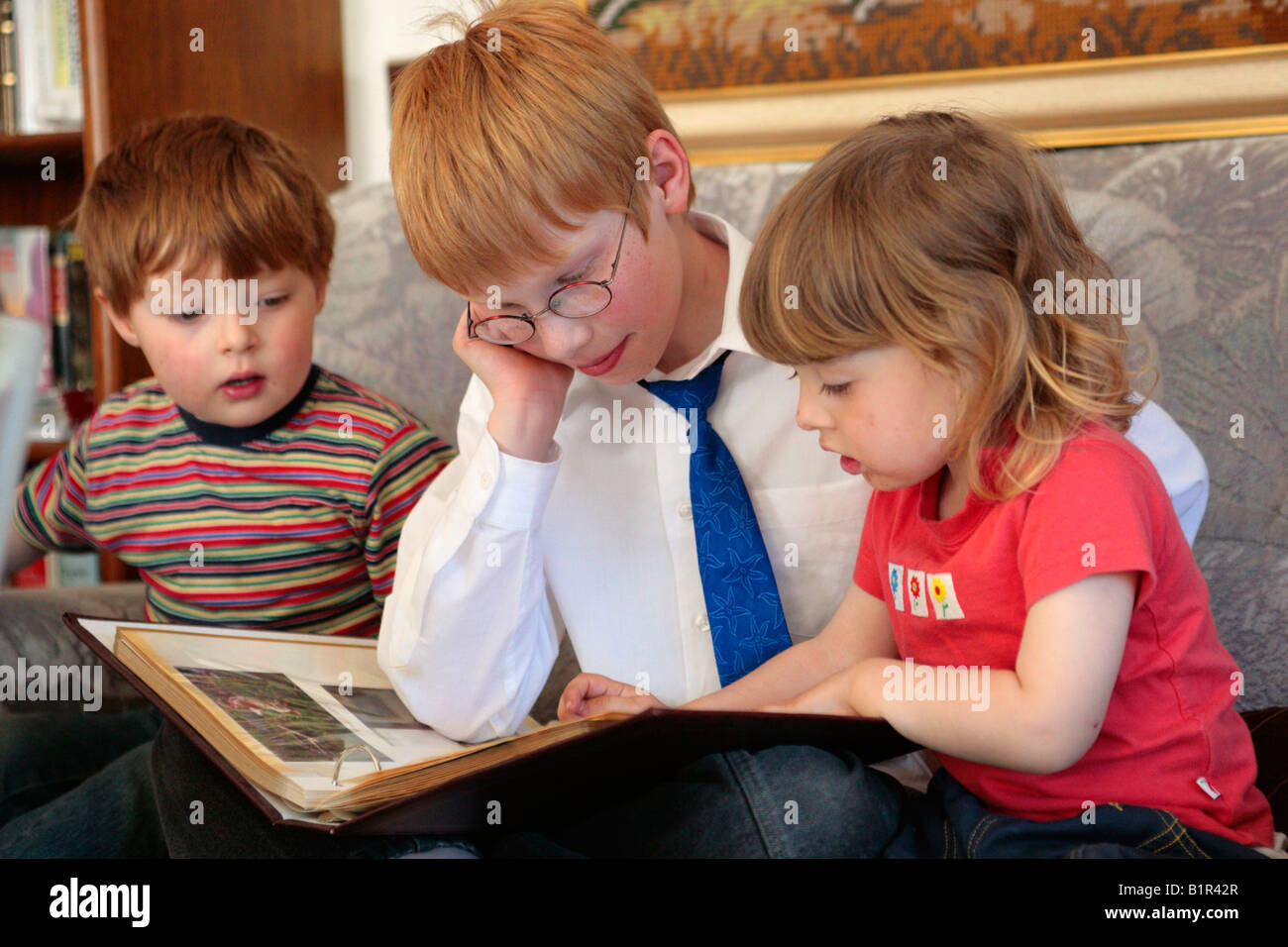 children looking at photo album Stock Photo - Alamy