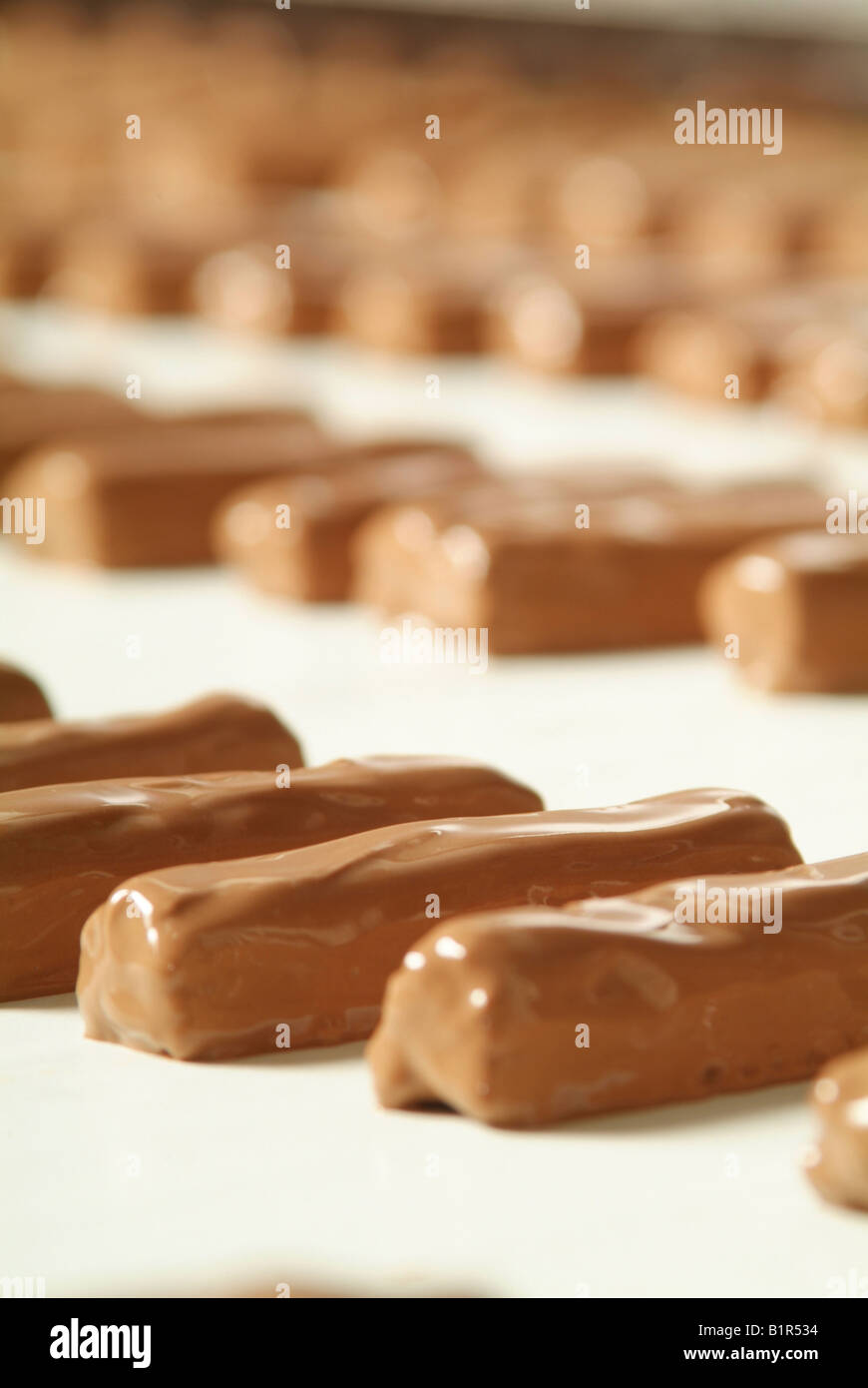 Lines of chocolate bars on conveyor belt in a factory Stock Photo - Alamy