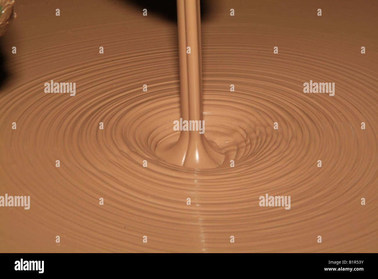 liquid chocolate pouring into a pool of chocolate Stock Photo - Alamy