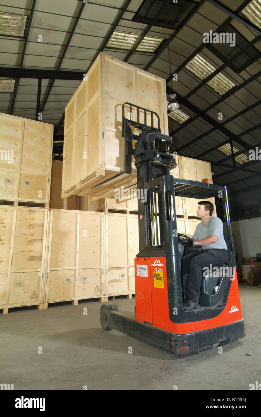 A man operating a fork-lift truck in a warehouse Stock Photo - Alamy