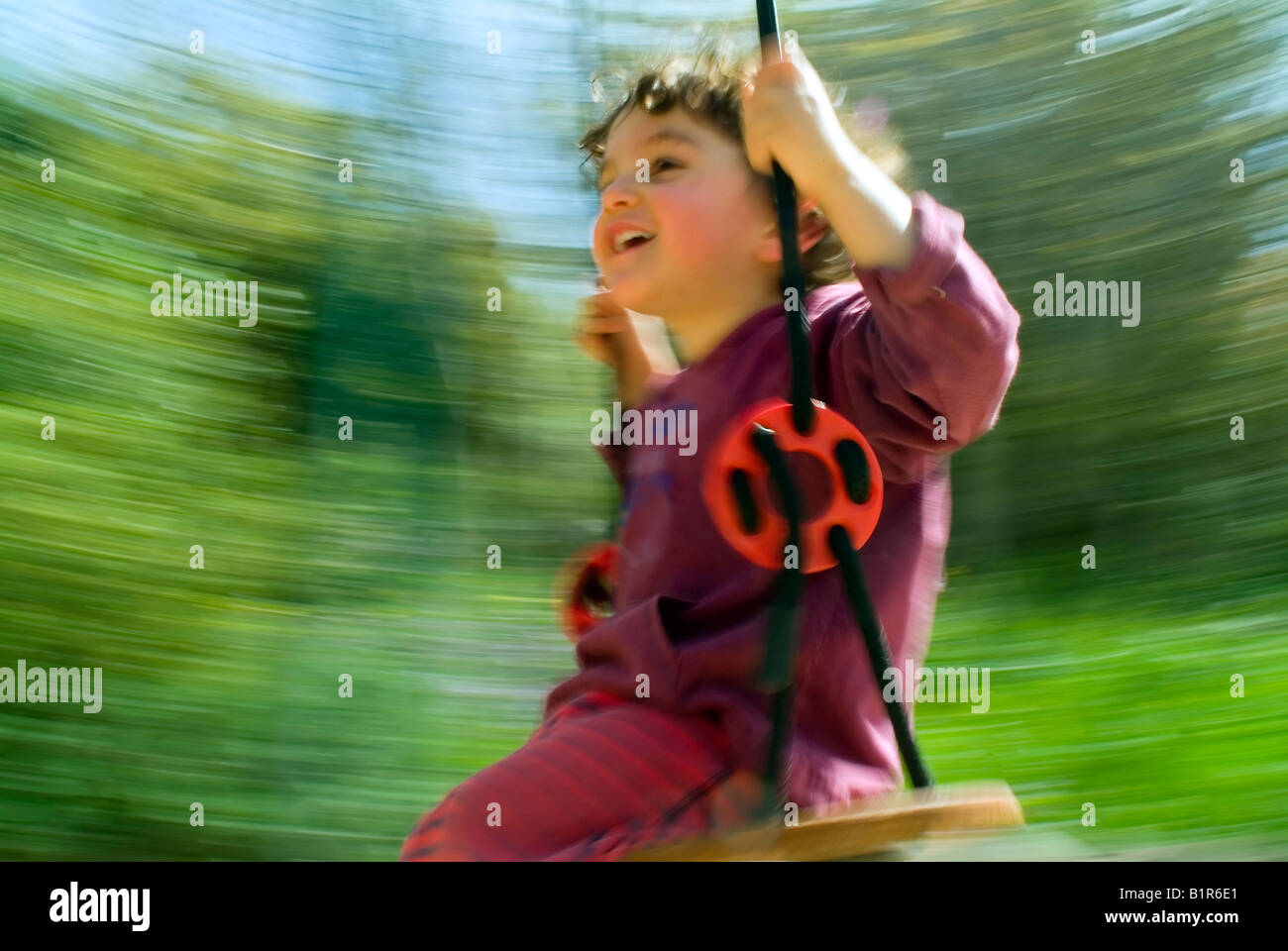smilling boy on a swing with motion blur Stock Photo - Alamy