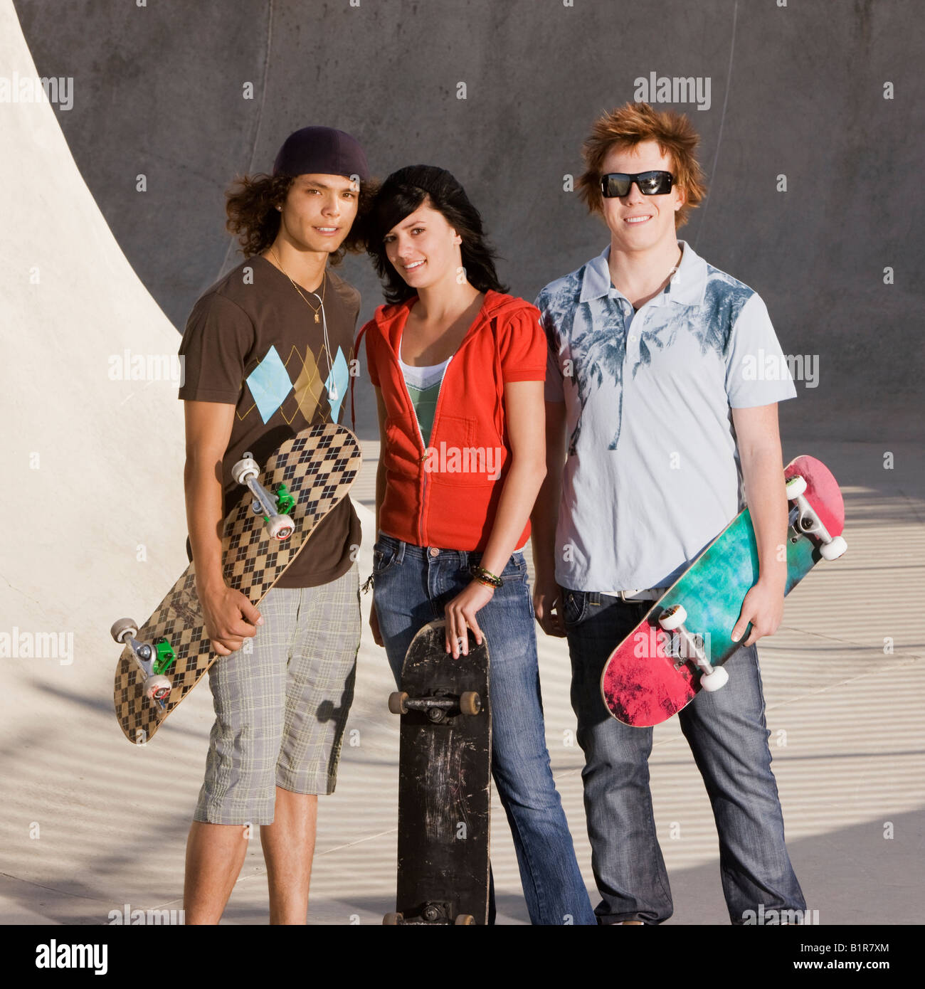 Three kids hang out at the skate park Stock Photo - Alamy