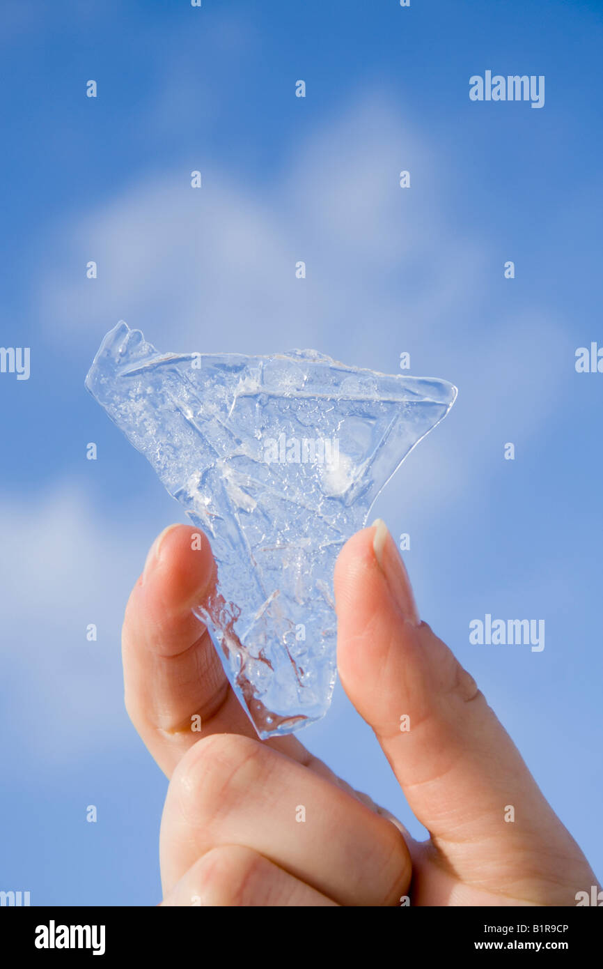 bit of ice in hand on sky background Stock Photo - Alamy