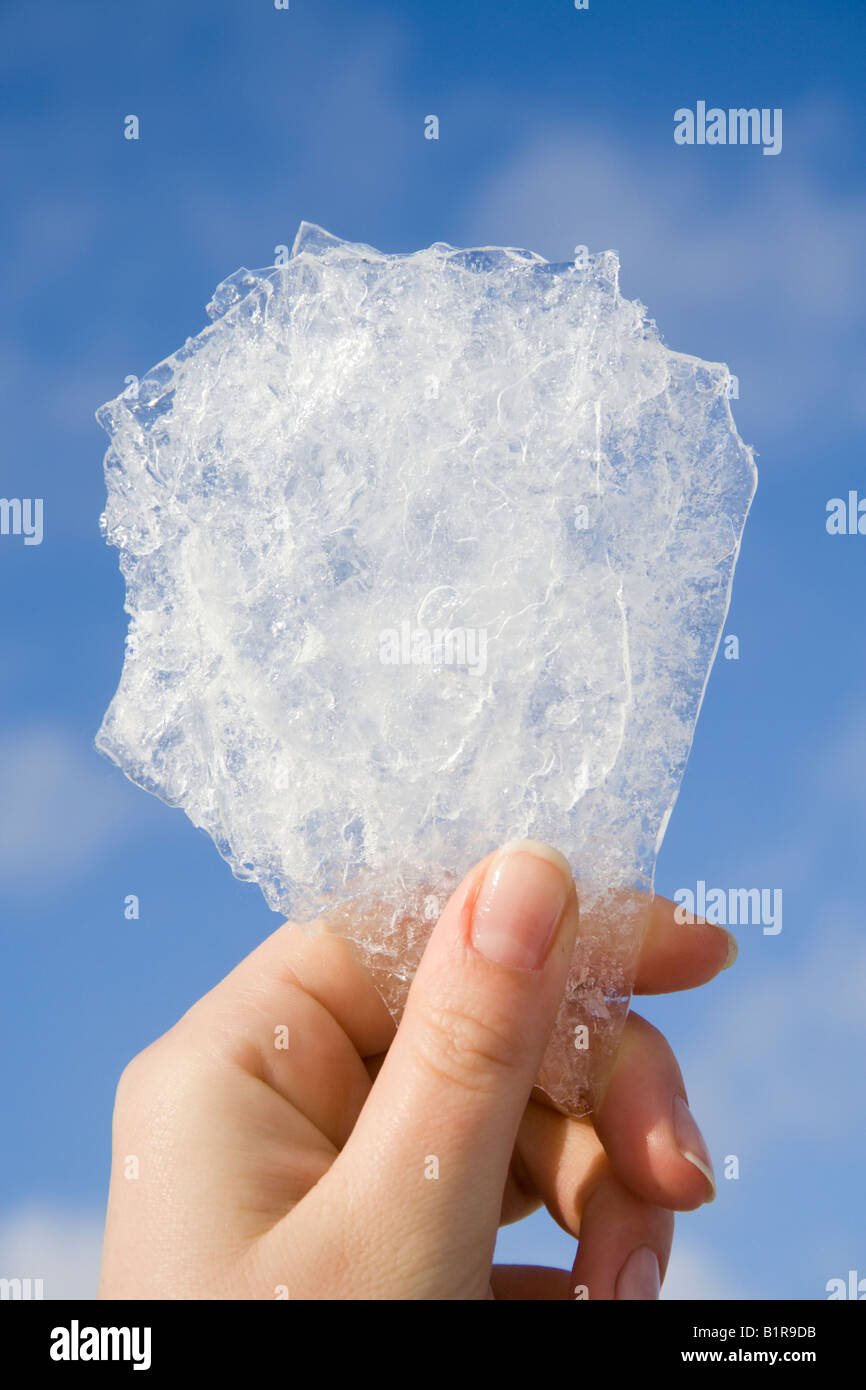 bit of ice in hand on sky background Stock Photo - Alamy