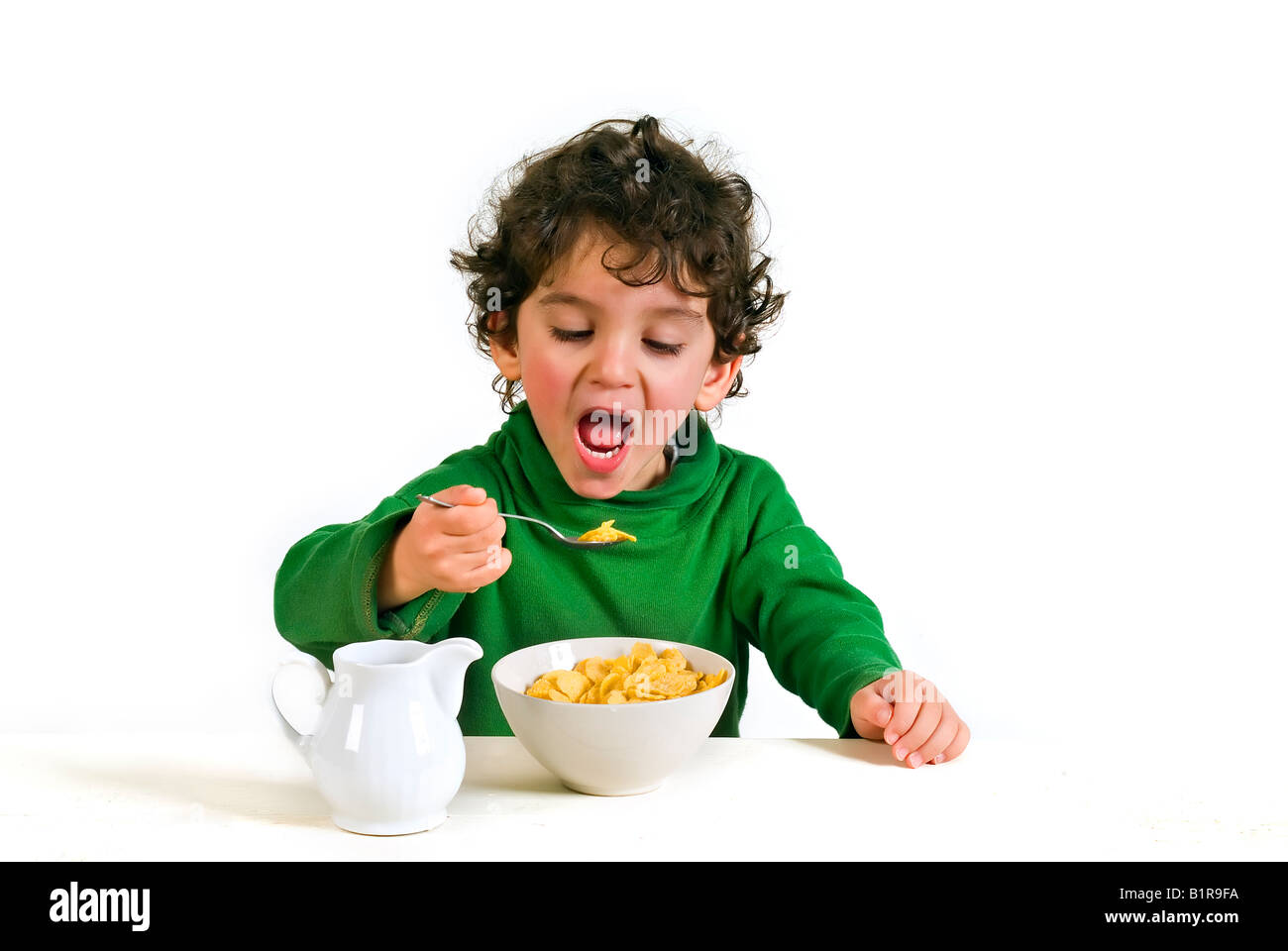 young boy eating cereals isolated on white Stock Photo - Alamy