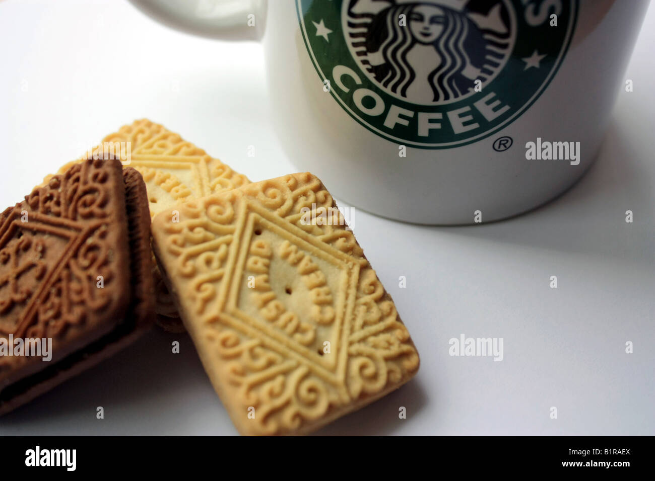 Dunking biscuits with a mug of coffee close by Stock Photo - Alamy