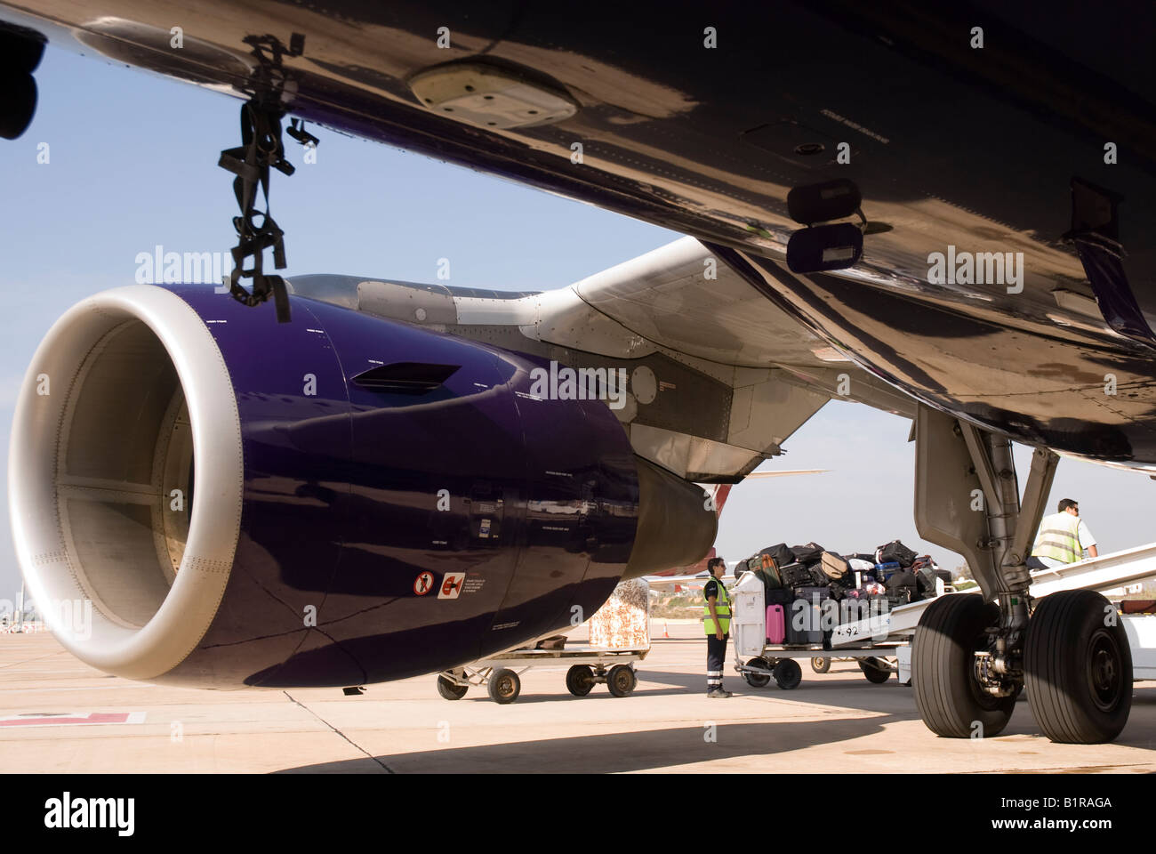Aeroplane jet engine and baggage loading at airport Stock Photo - Alamy