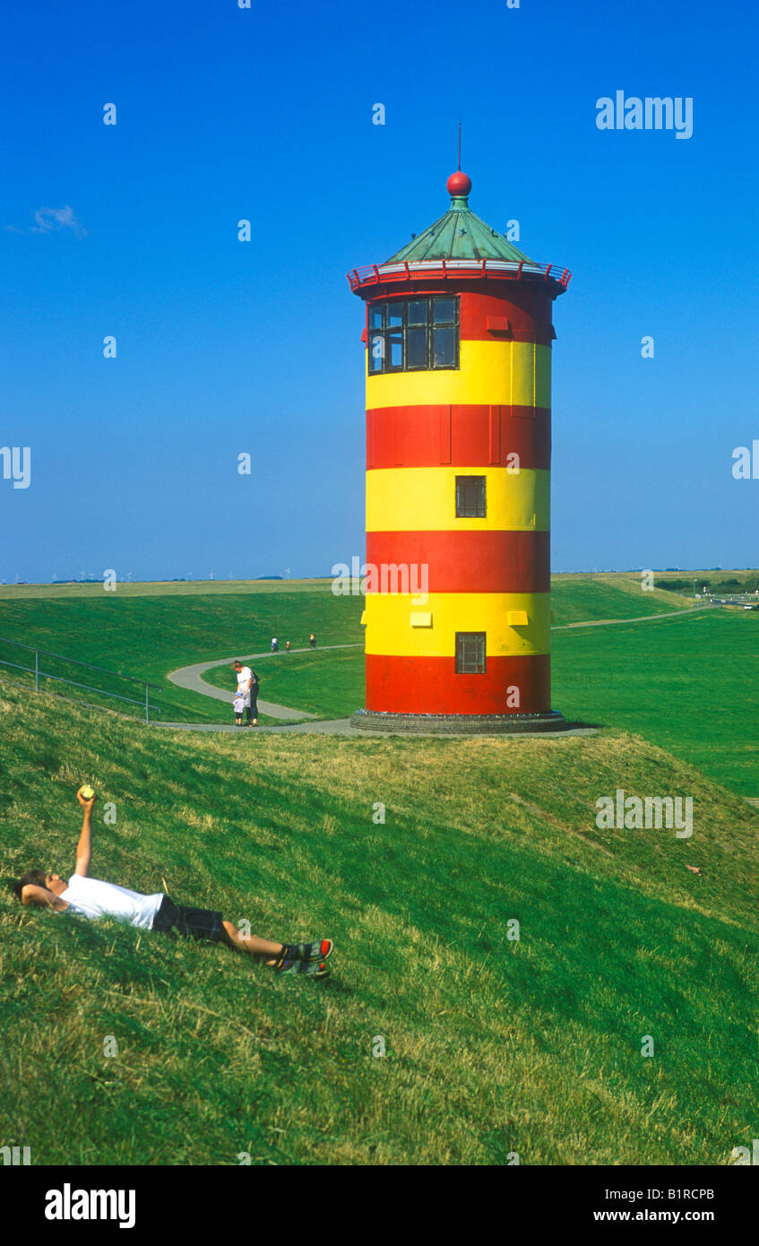 red and yellow lighthouse of Pilsum in East Friesland in Northern ...