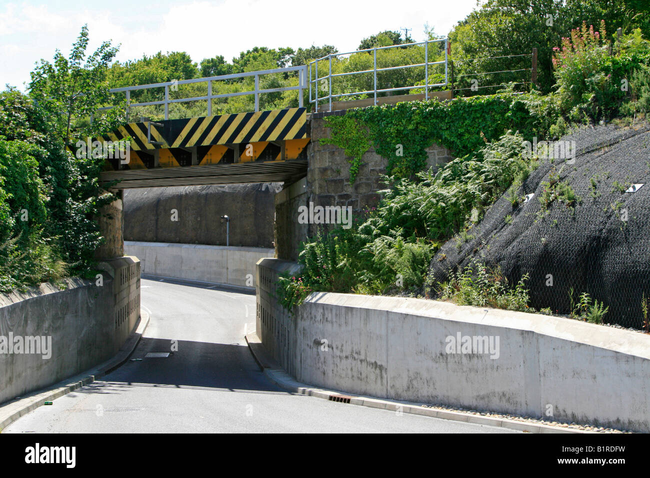 narrow railway strengthened with concrete walls underbridge near par ...