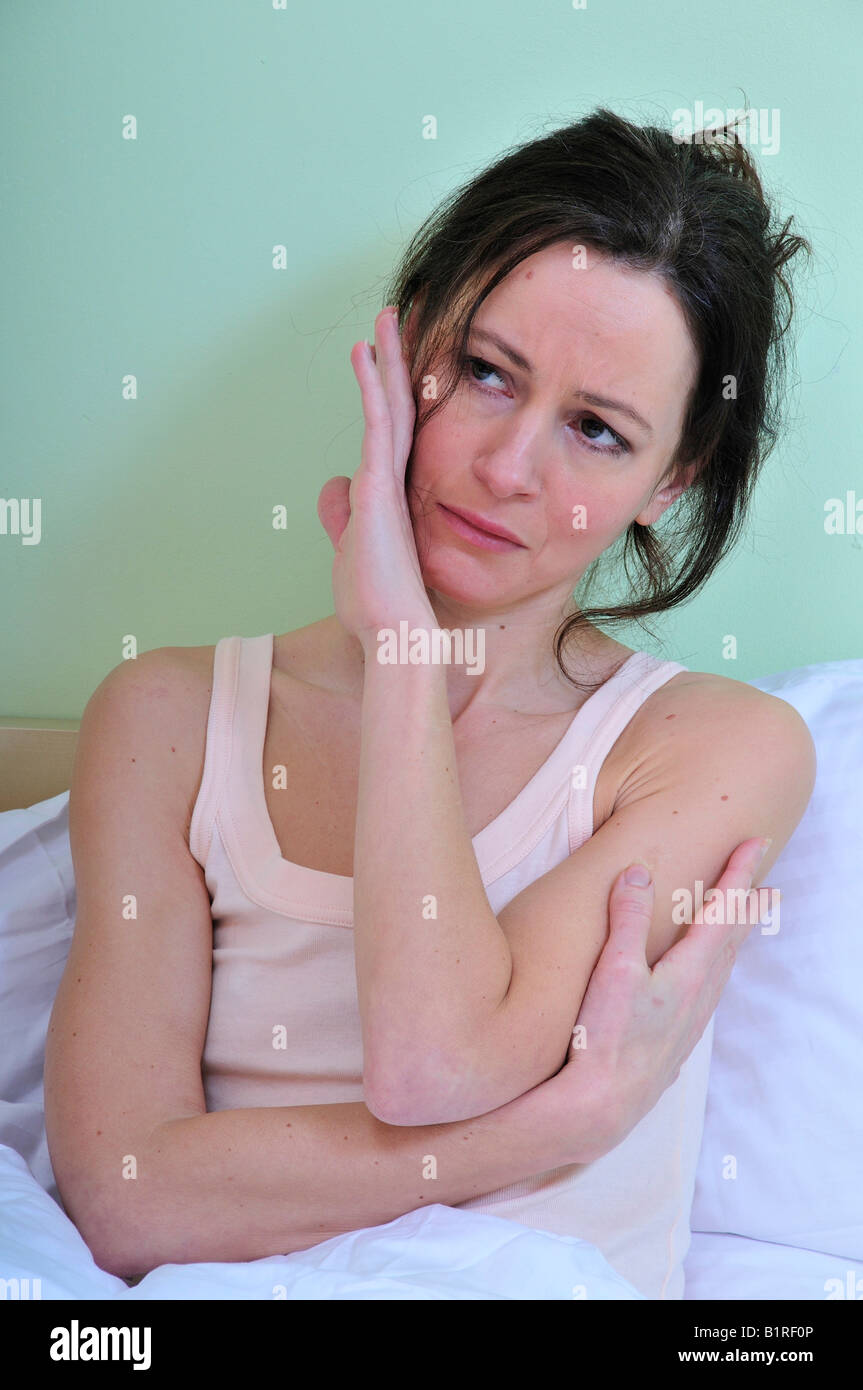 Portrait of an adult woman, crying, sad and depressed, alone in the bed ...