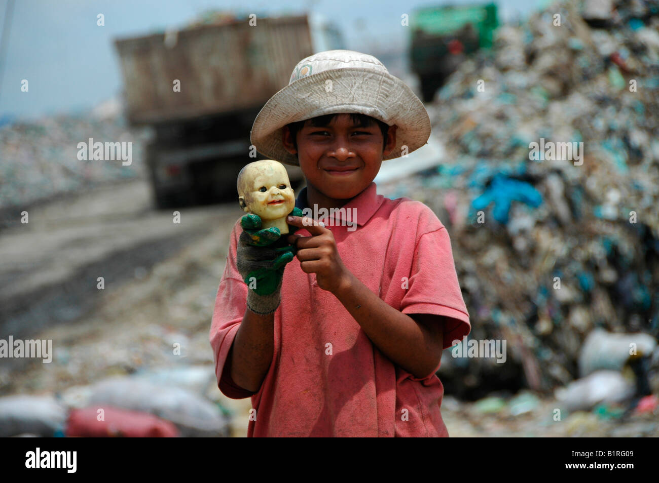 Child rummaging through a garbage dump finds a dolls head on the Stung ...