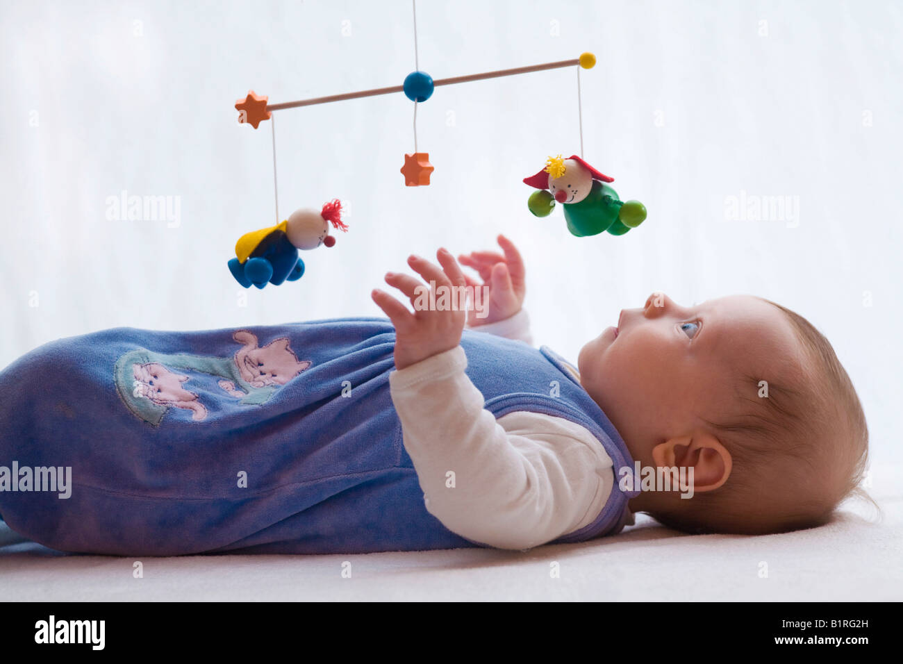 3-month-old baby fascinated by the movement of a toy pendulum Stock ...