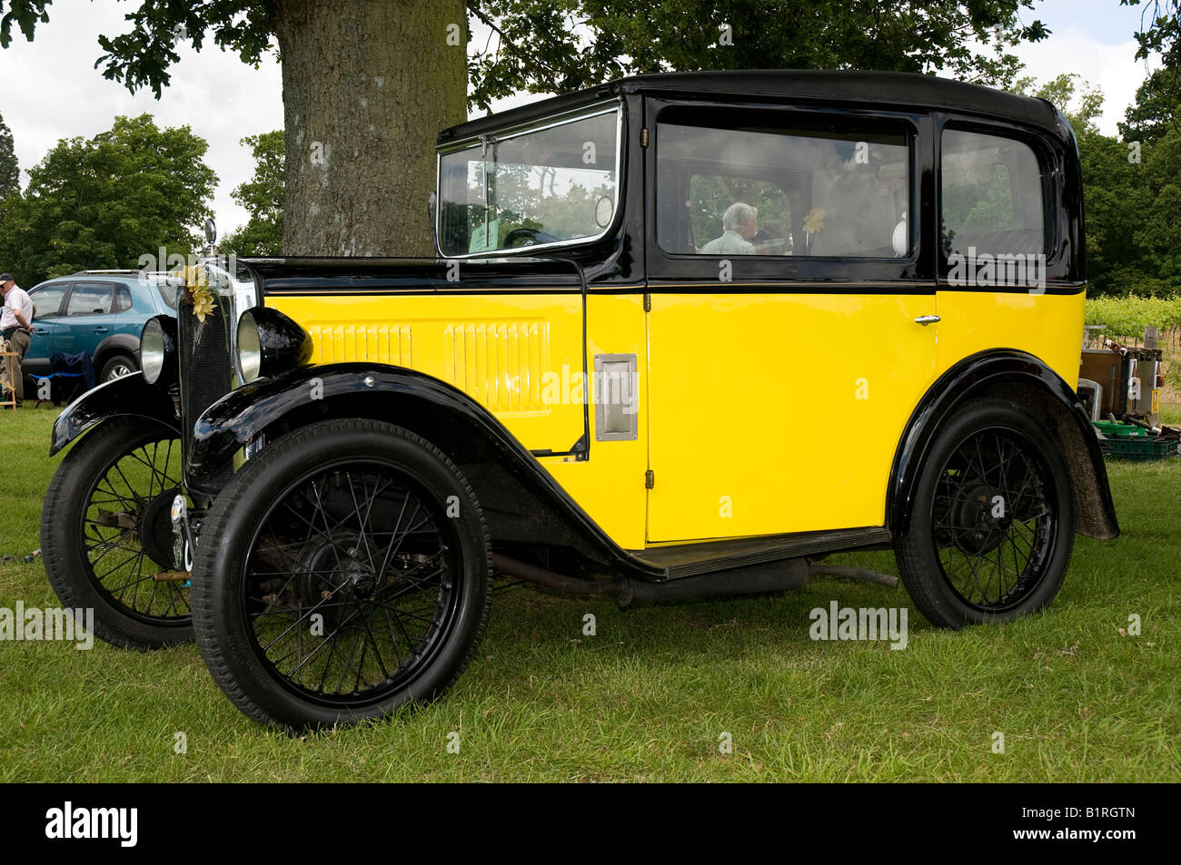 Yellow and Black Austin 7 parked under a tree at a rally in the New ...