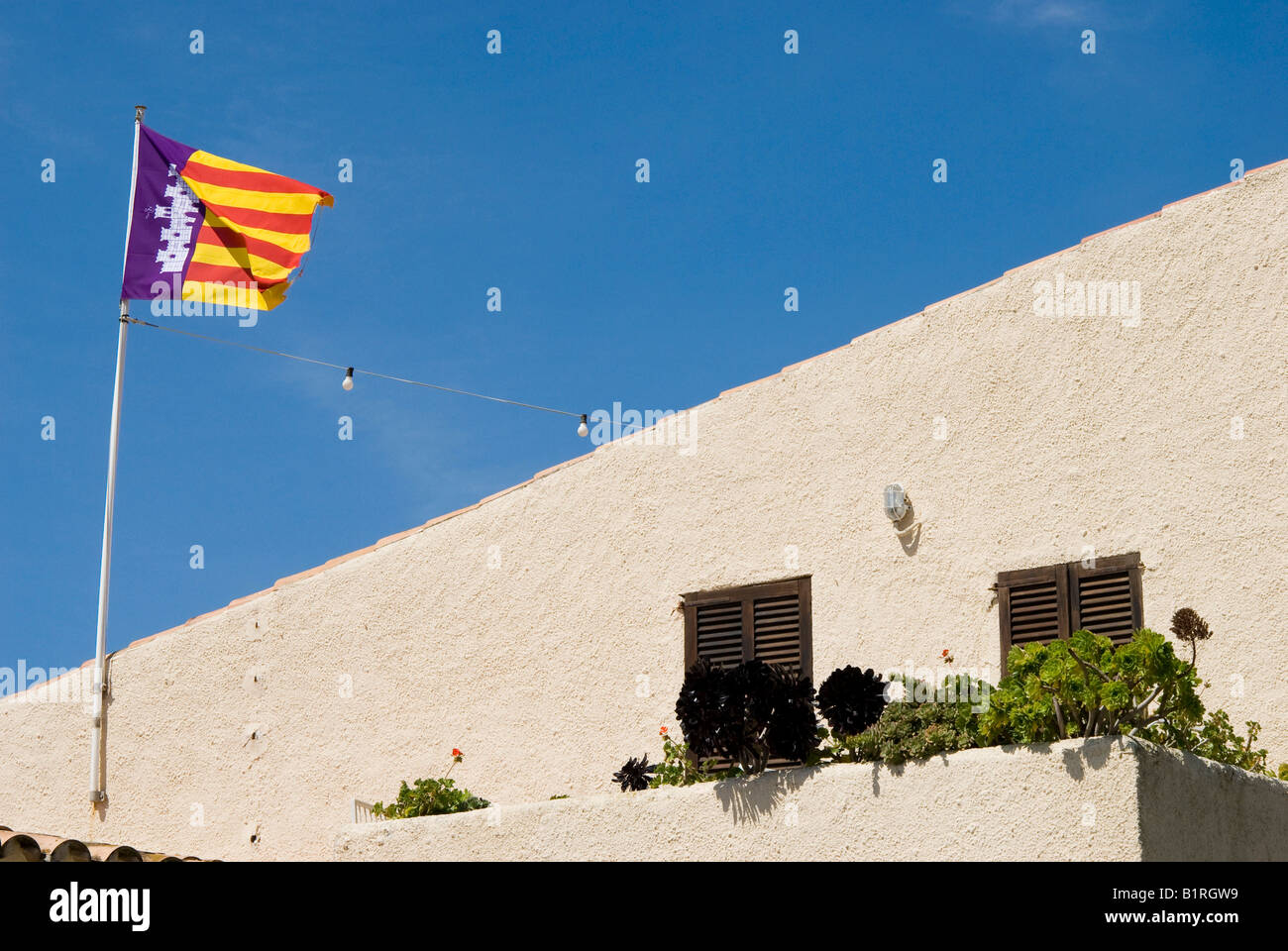Majorcan flag above a house with a balcony in Platja des Trenc, Majorca ...