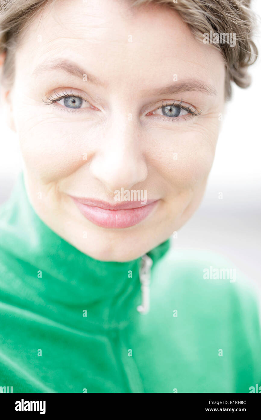 Close-up, woman wearing a green jacket smiling Stock Photo - Alamy
