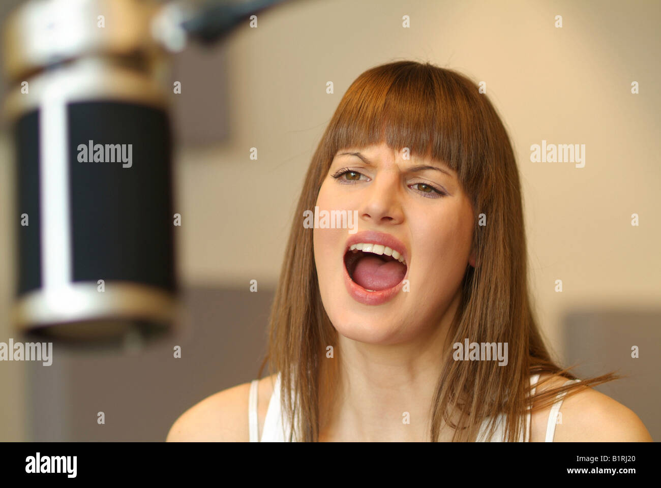 Emotional female singer, microphone in front of her Stock Photo - Alamy