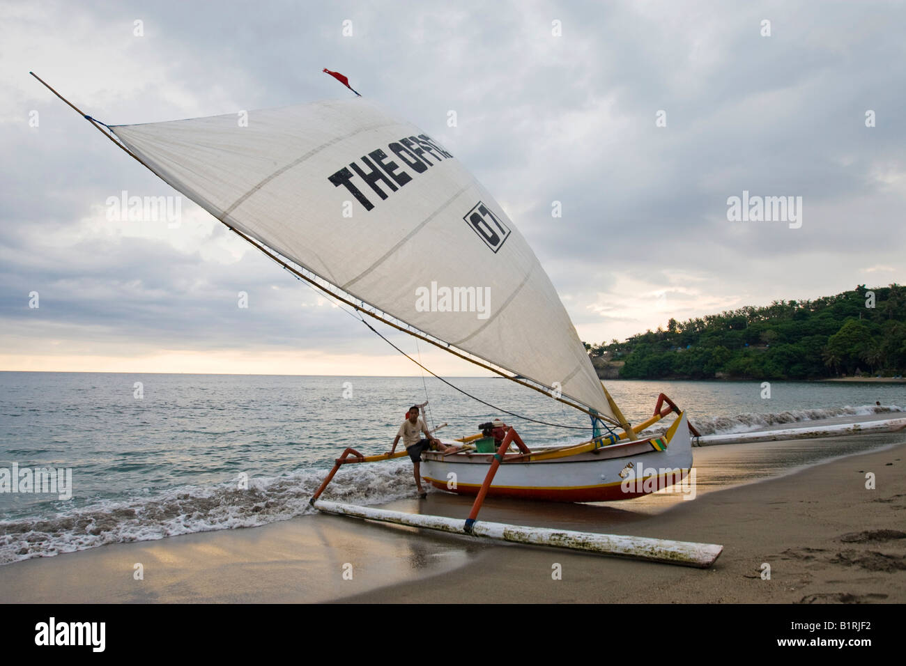 Outrigger fishing boat with open sail on Senggigi Beach, Lombok Island ...
