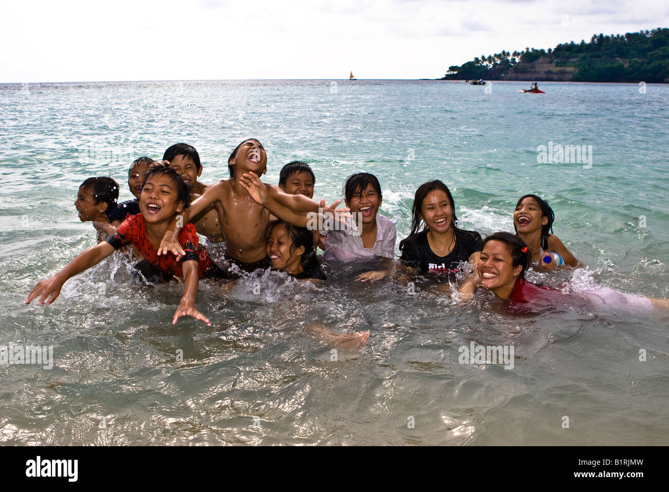 Children playing happily in the sea, Lombok Island, Lesser Sunda ...