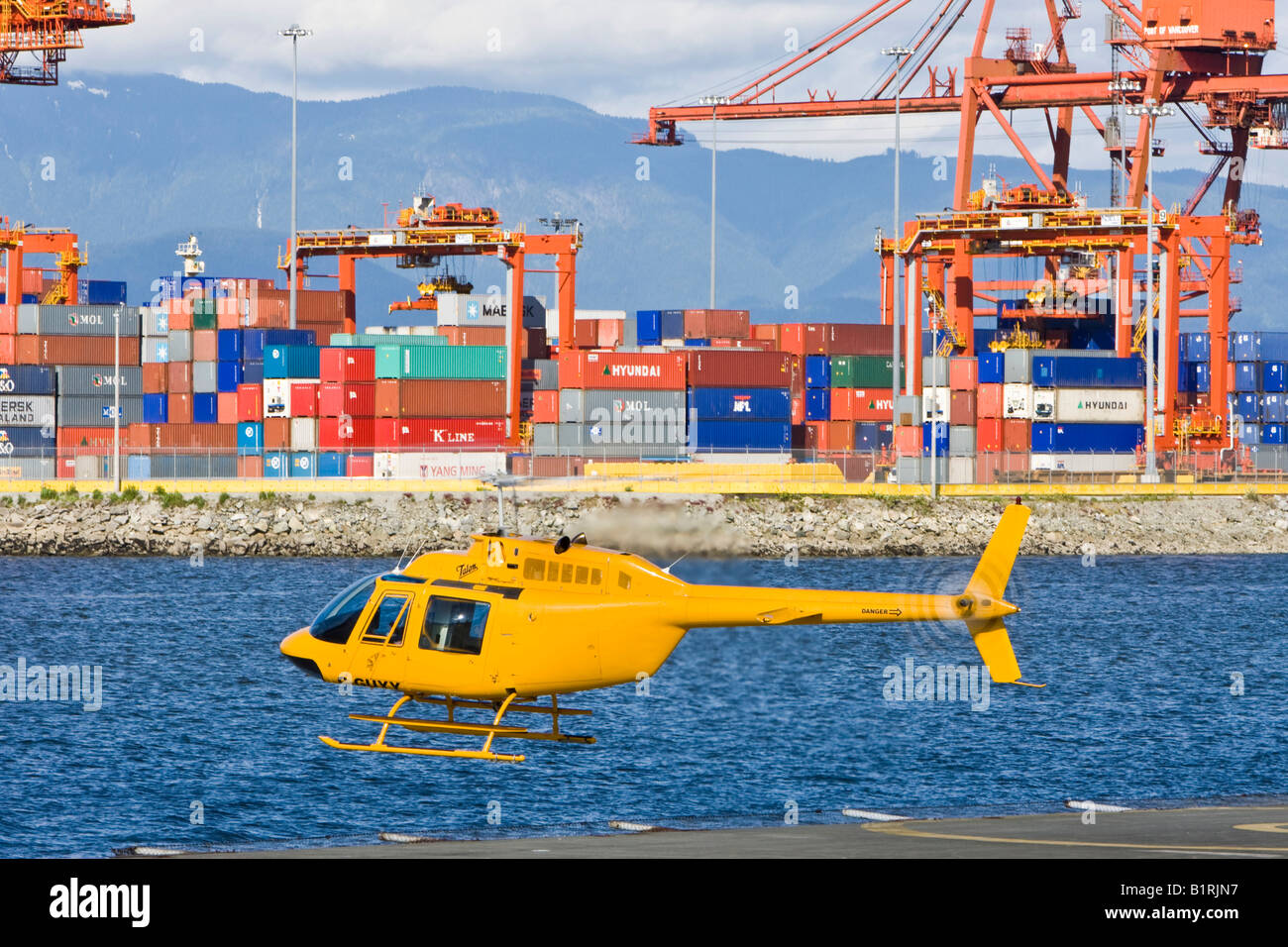A helicopter taking off, in the back Vancouver container port ...