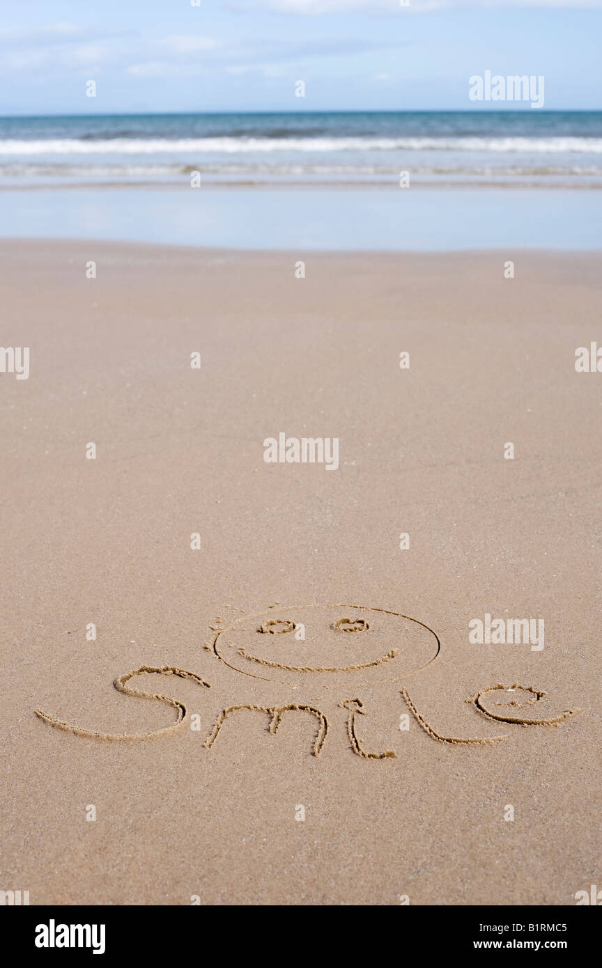Smile and face drawn in the sand on a beach Stock Photo - Alamy