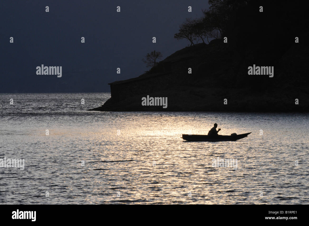Sunset, back light, fisherman in a boat, Lake Atitlán, Guatemala ...