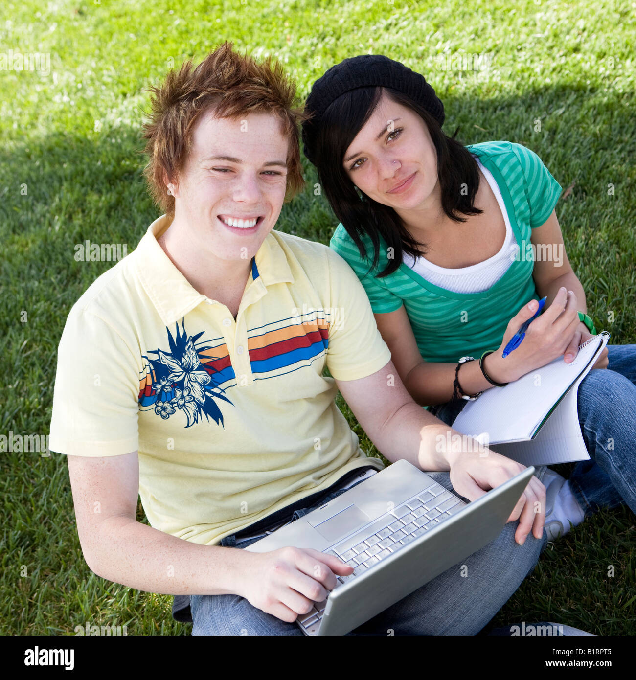 Teen couple do homework in the grass Stock Photo - Alamy