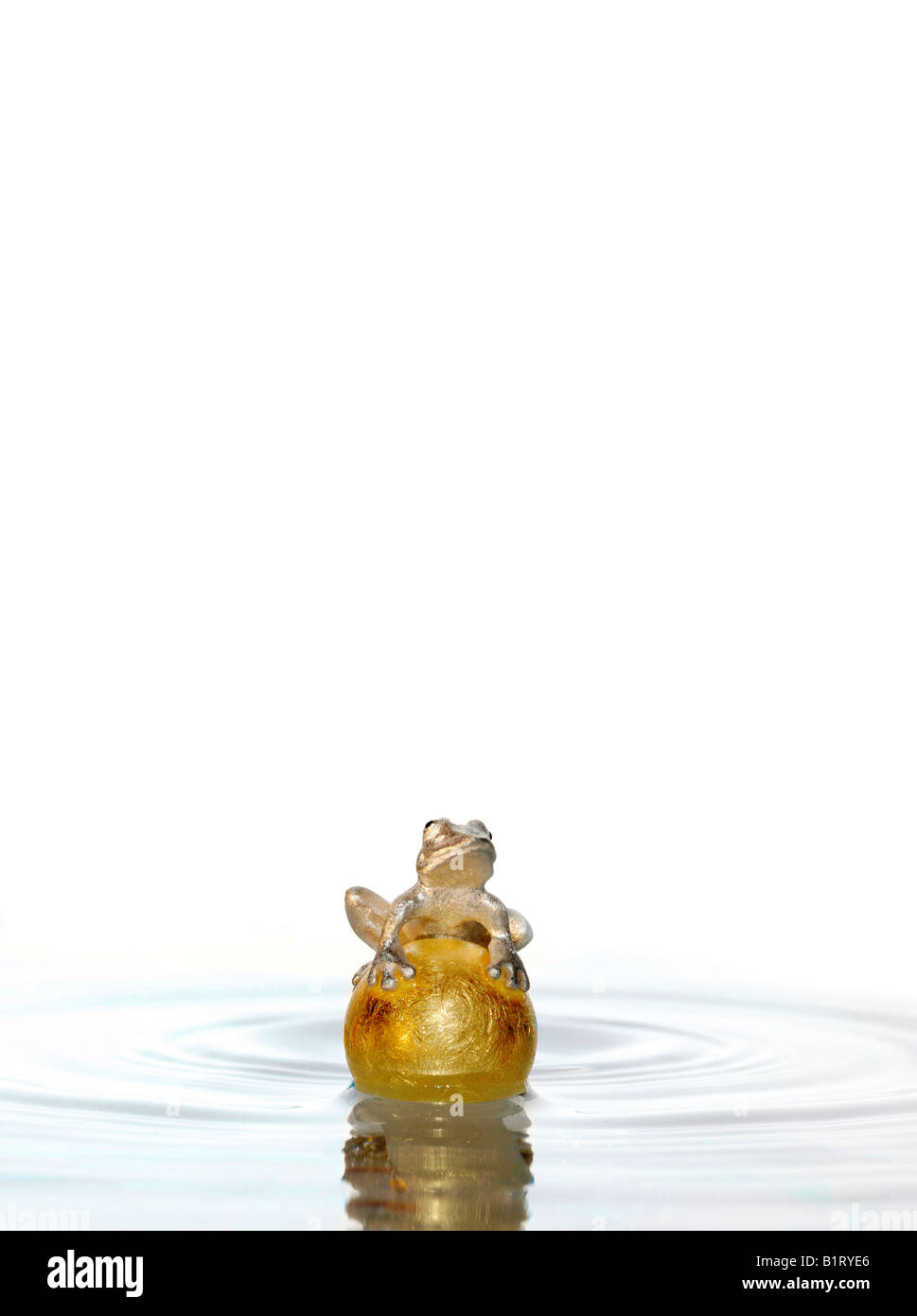 Frog Prince balancing in water on a golden ball Stock Photo - Alamy