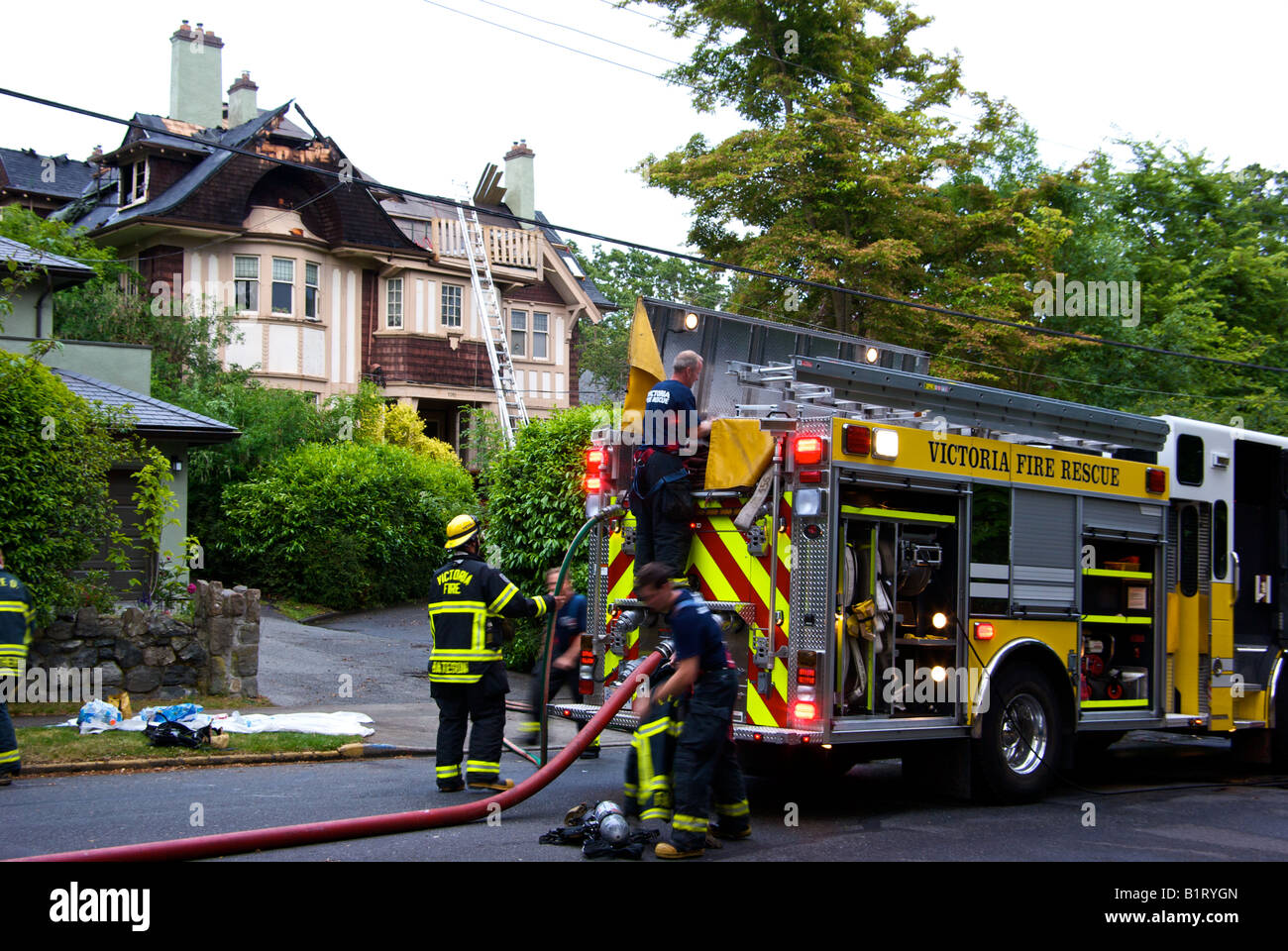 Fire crew loading up fire truck after putting out a house fire motion ...