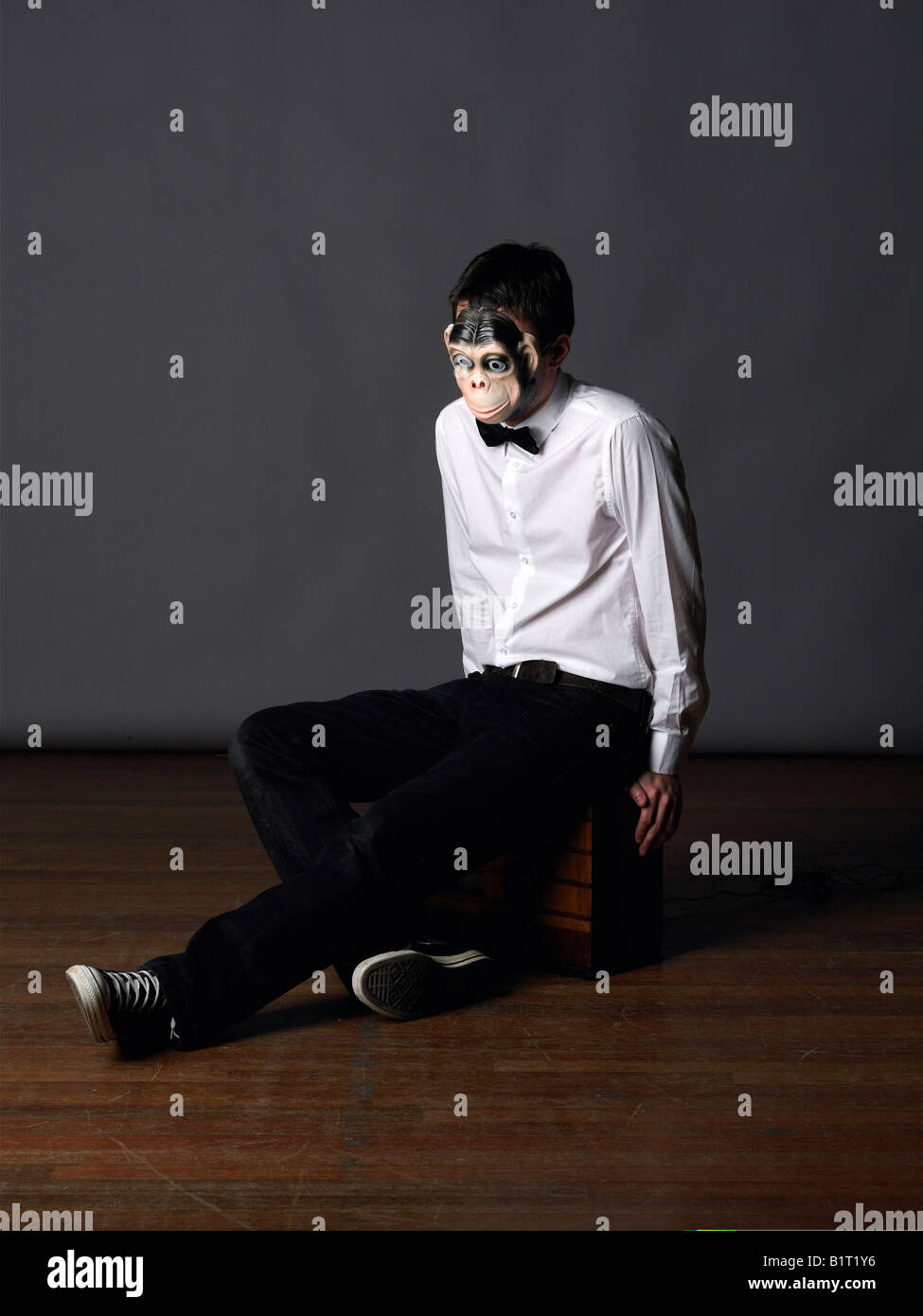 A man in a monkey mask rests on an old radio Stock Photo - Alamy