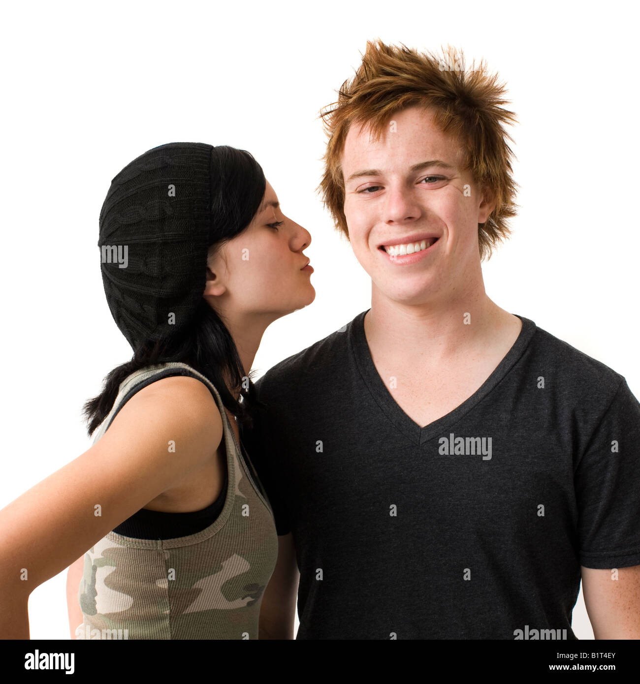 Teen couple against white background kiss Stock Photo - Alamy
