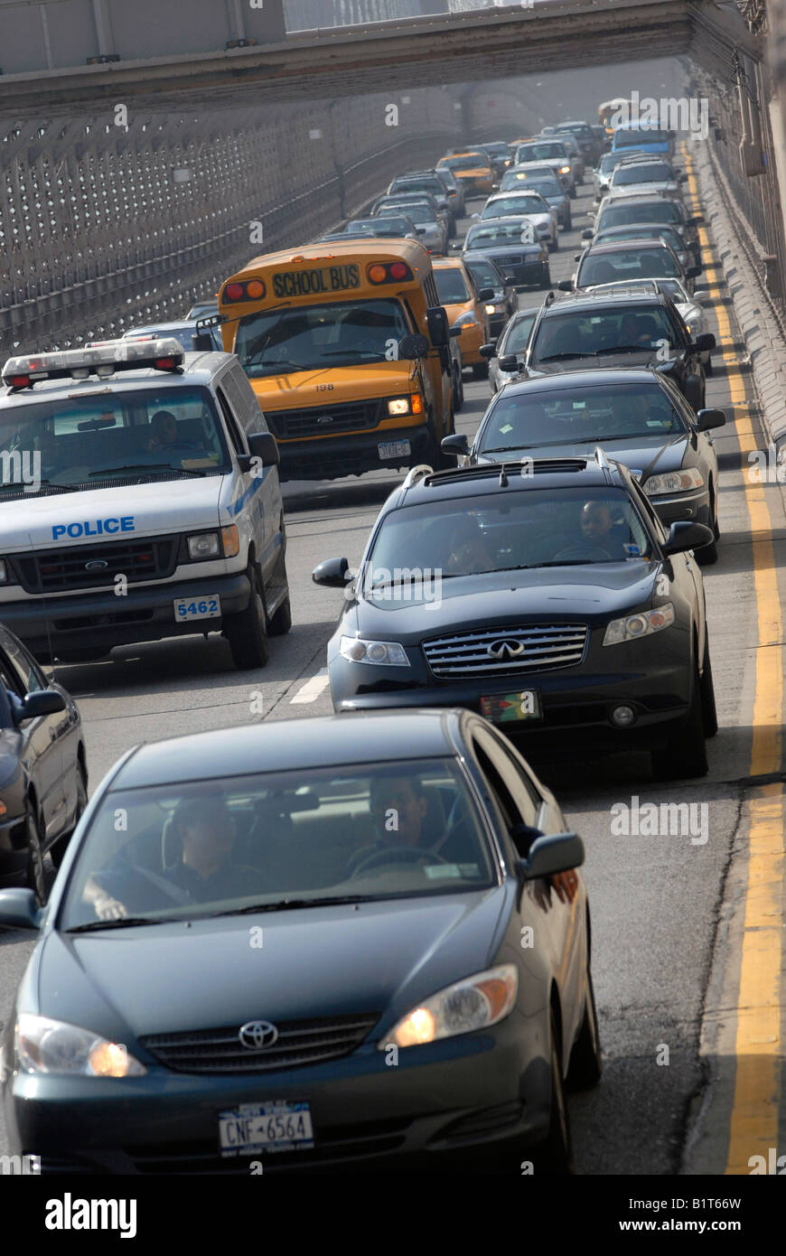 Commuters in their cars and school bus in rush hour traffic jam on the ...