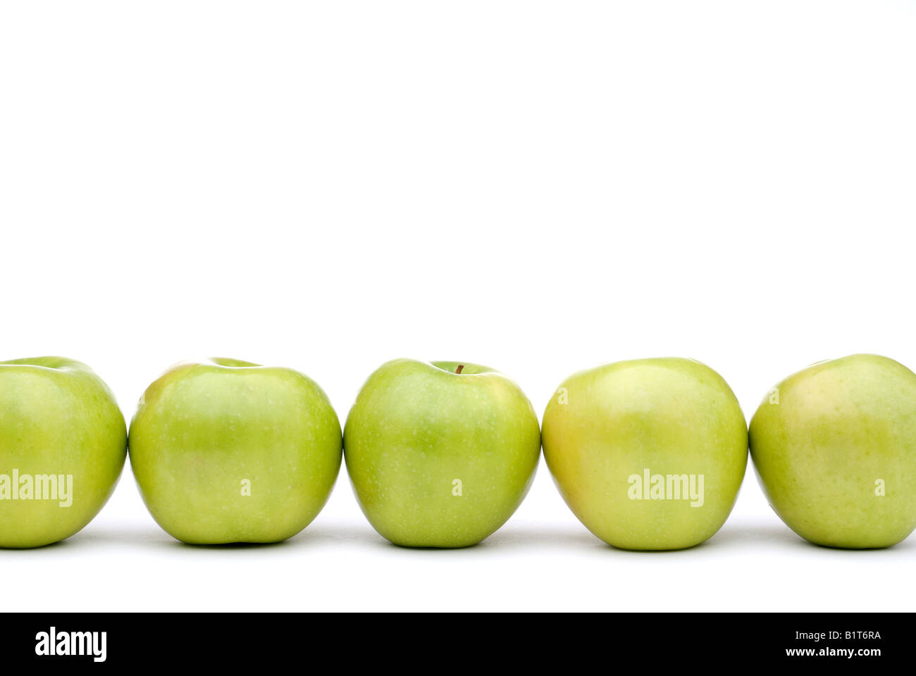 green apples line up on a white background Stock Photo - Alamy
