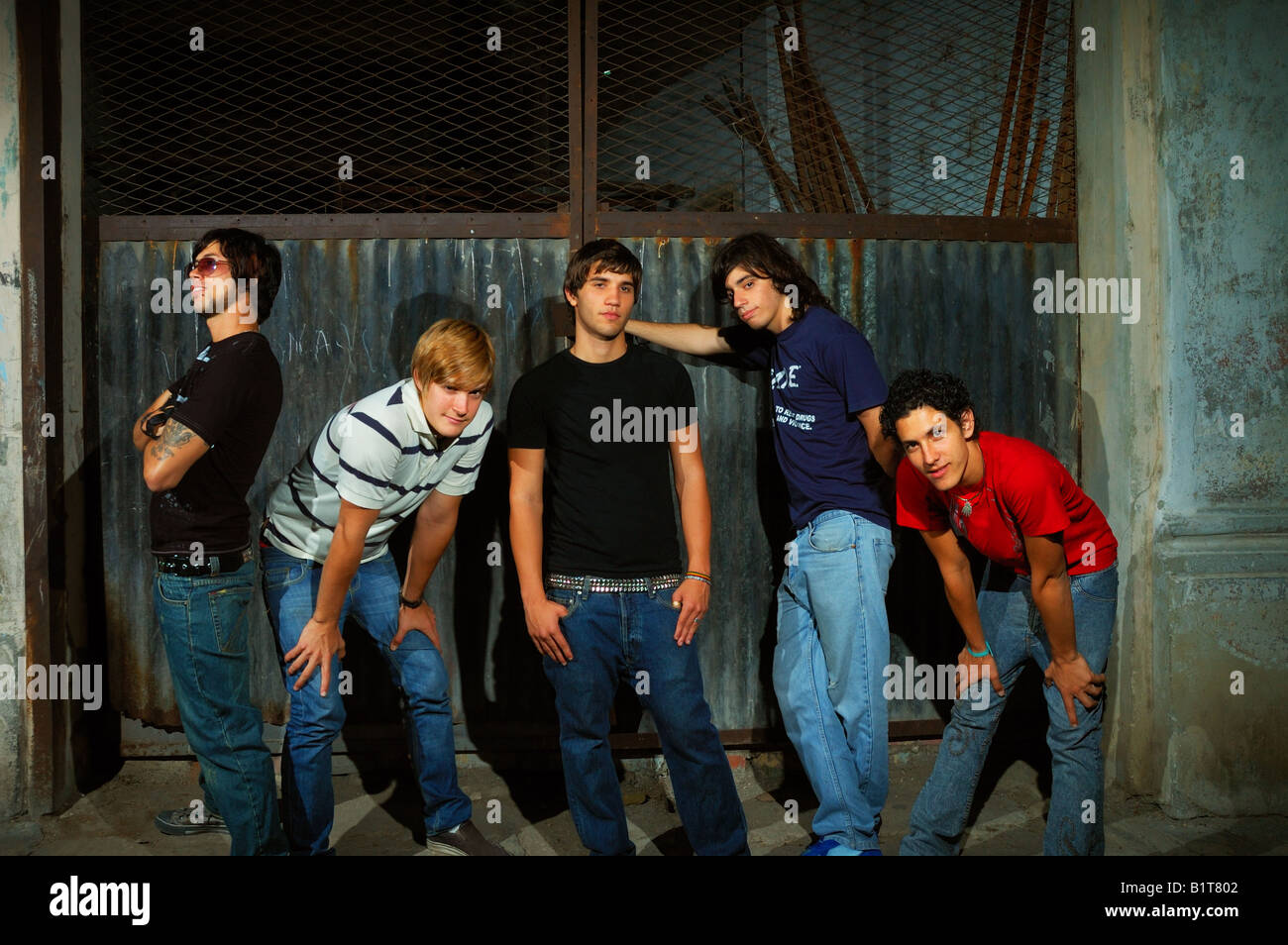 Casual group of teenagers standing against grunge wall Stock Photo - Alamy