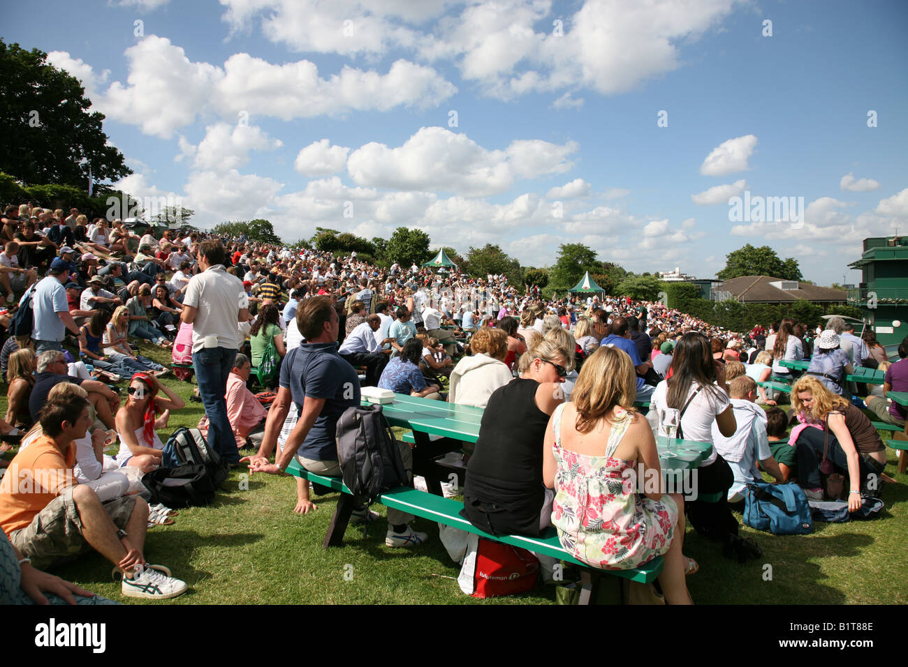 Groups of spectators sitting on Henman Hill at Wimbledon Tennis ...