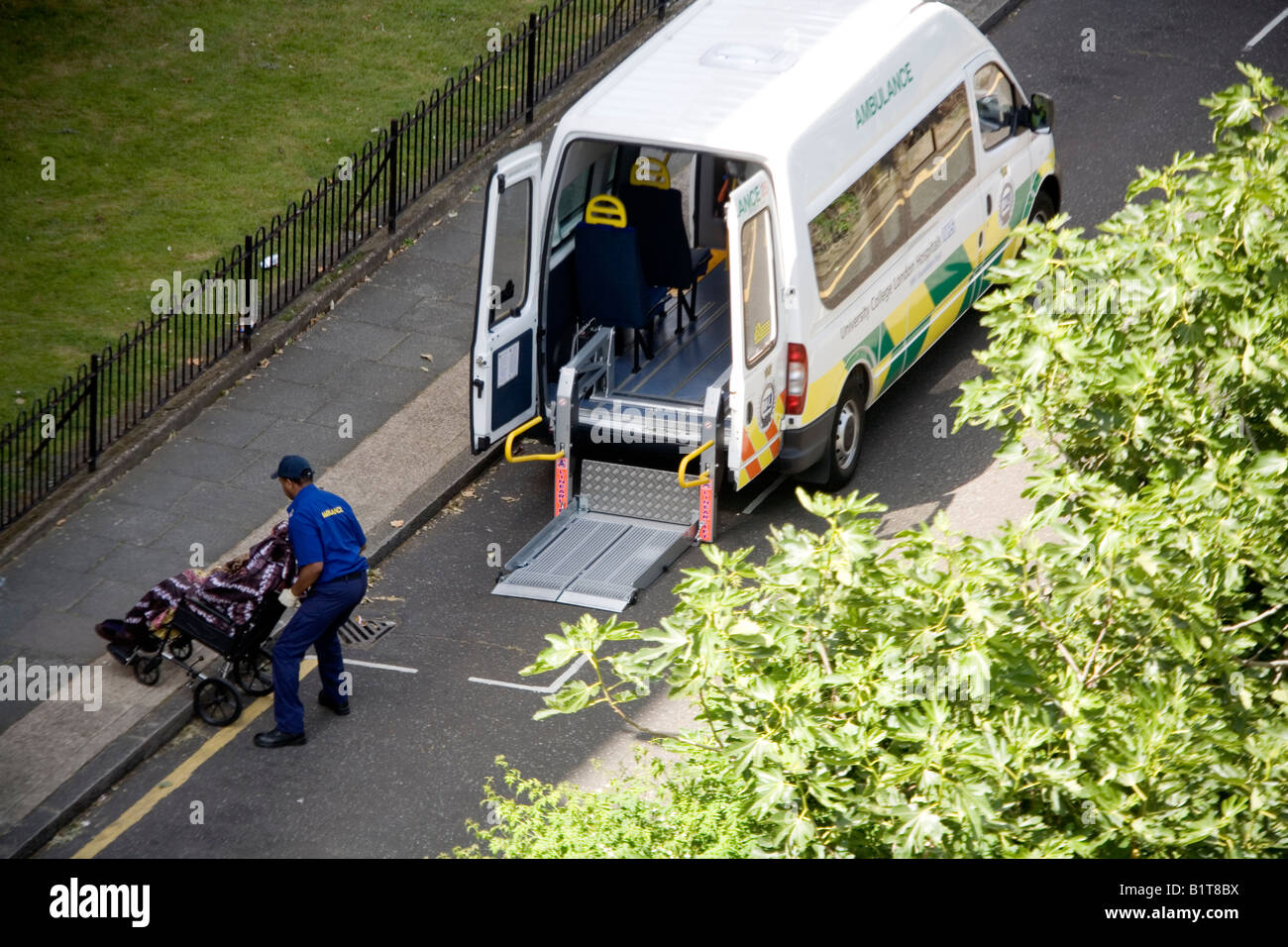 Ambulance driver pushing a wheelchair with a disable person over the ...